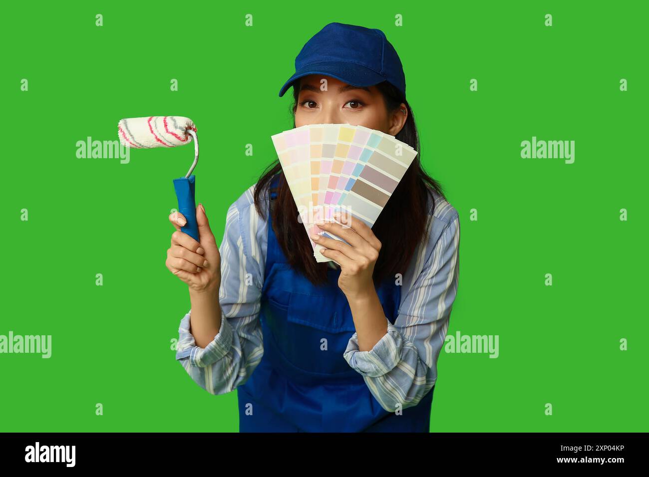 Female Asian painter with paint color palettes and roller on green ...