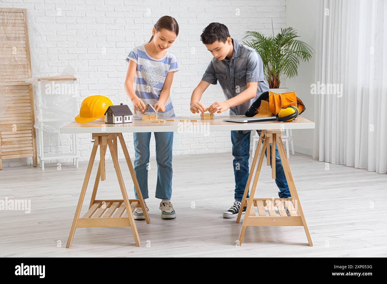 Little architects with building blocks at table in room Stock Photo - Alamy