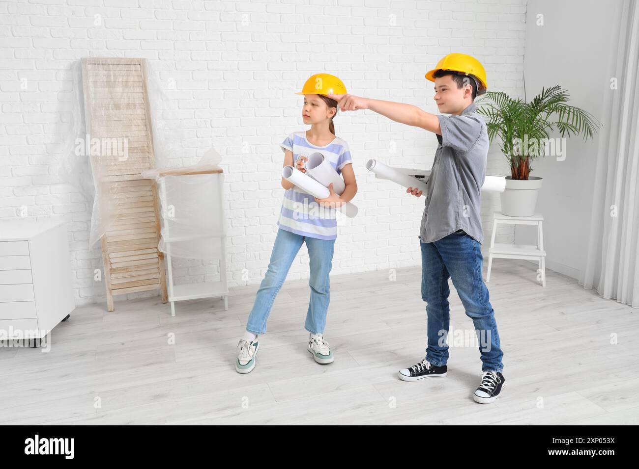Little architects with house plans in room Stock Photo - Alamy