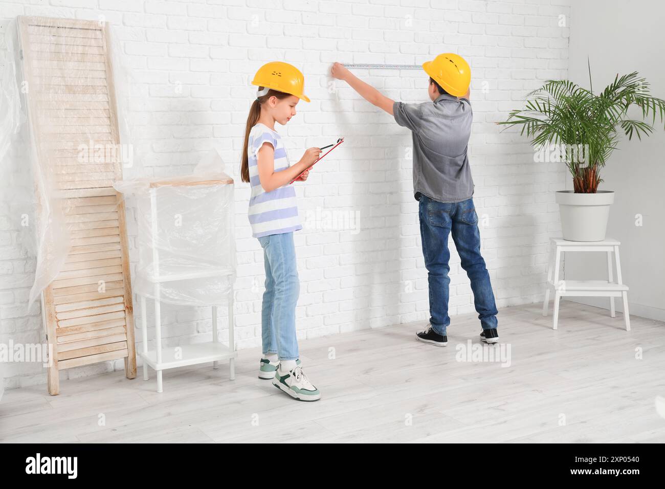 Little architects measuring wall in room Stock Photo - Alamy