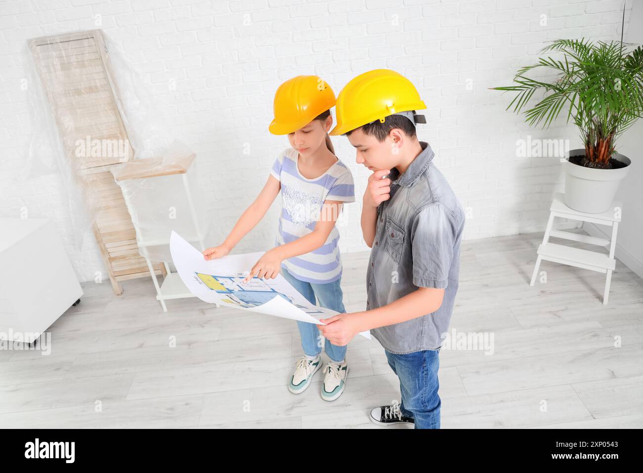 Little architects with house plan in room Stock Photo - Alamy