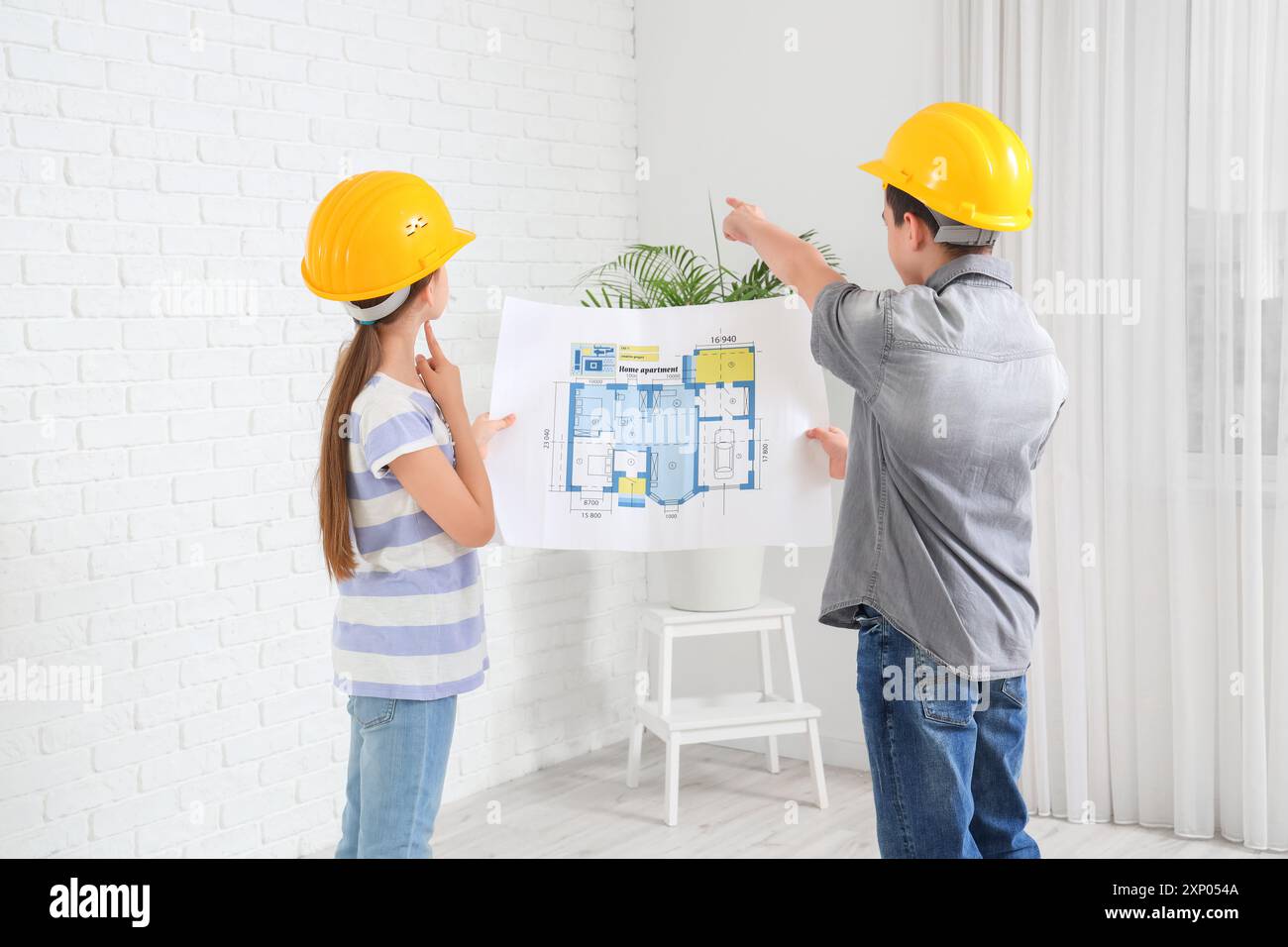 Little architects with house plan in room, back view Stock Photo - Alamy