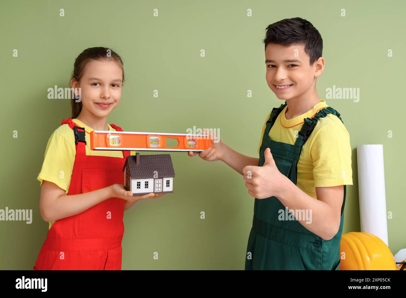 Little architects with house model and level on green background Stock ...