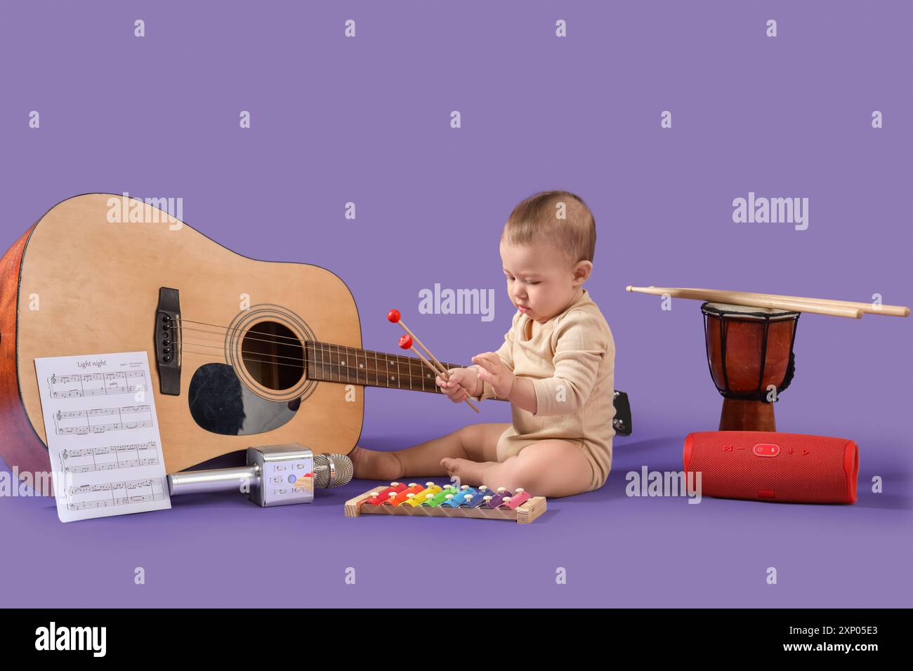 Cute baby artist with musical instruments on lilac background Stock ...