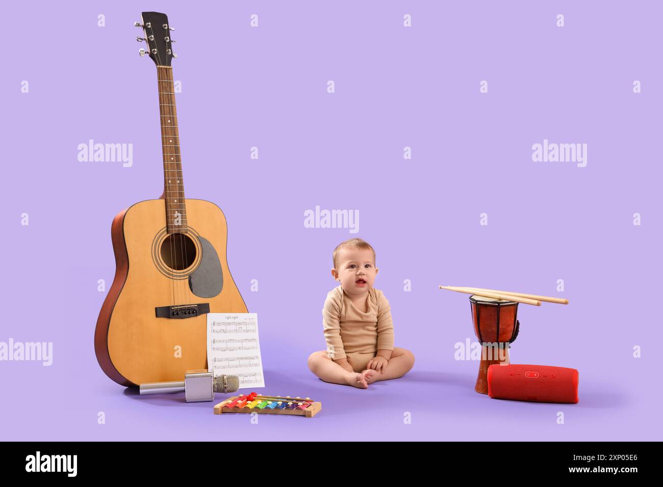 Cute baby artist with musical instruments on lilac background Stock ...