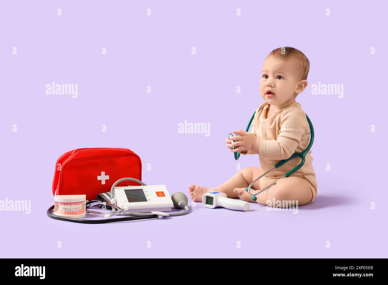 Cute baby doctor with medical supplies on lilac background Stock Photo ...