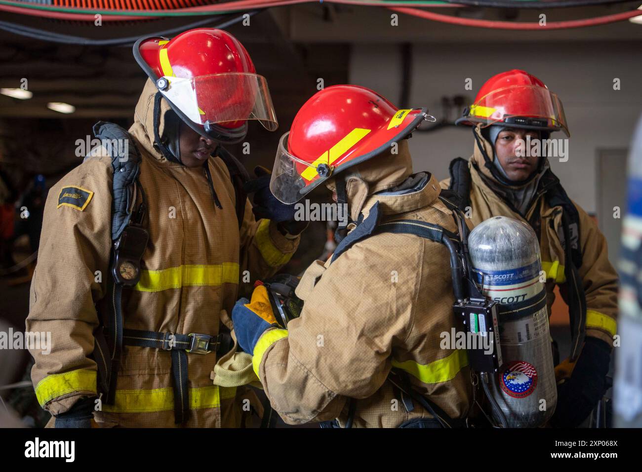 Sailors buddy check each other’s Firefighting ensembles in the hangar ...