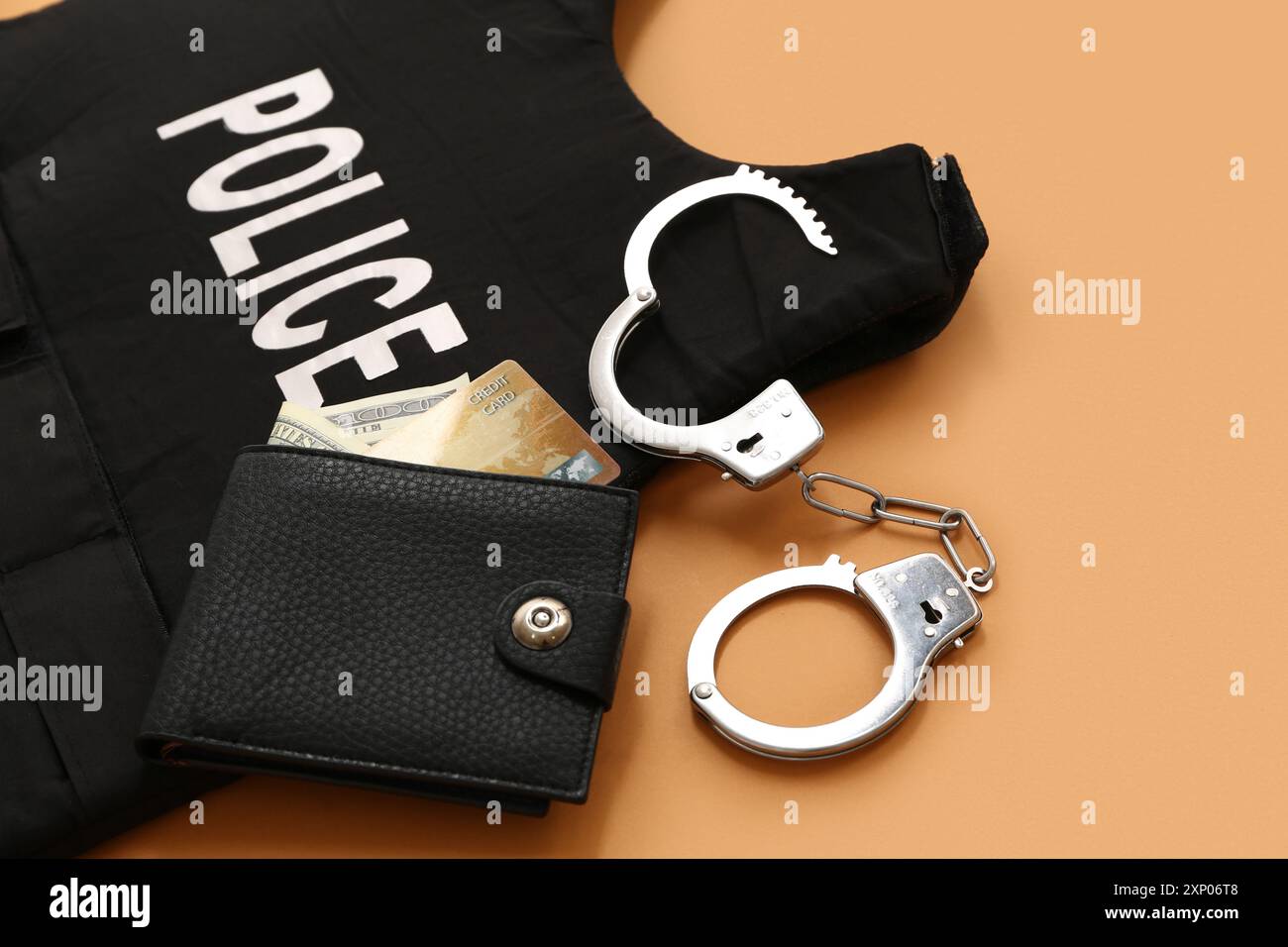 Wallet, policeman's body armor and handcuffs on color background ...