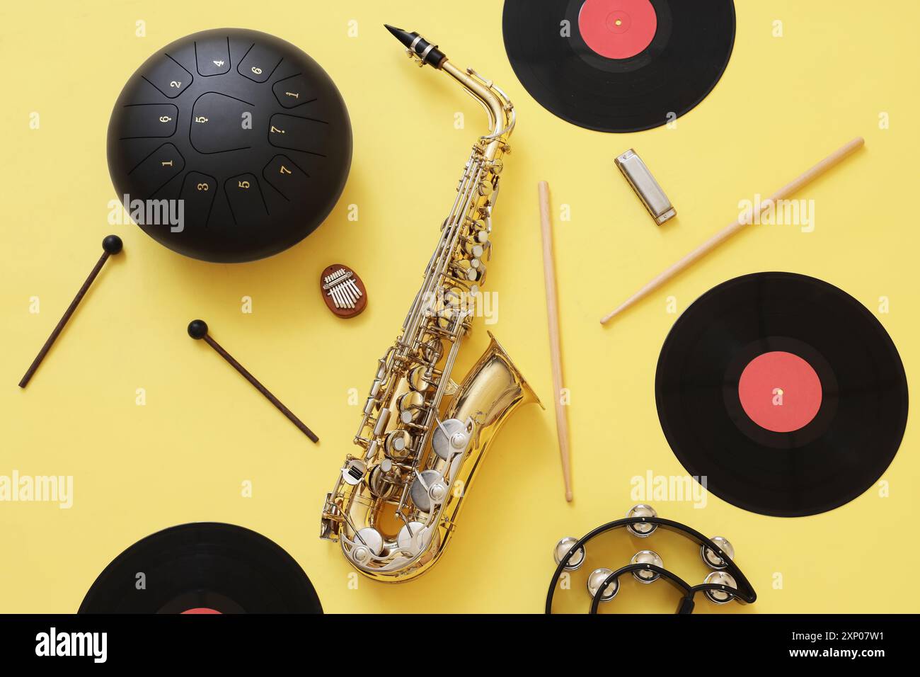 Different musical instruments and vinyl disks on yellow background ...