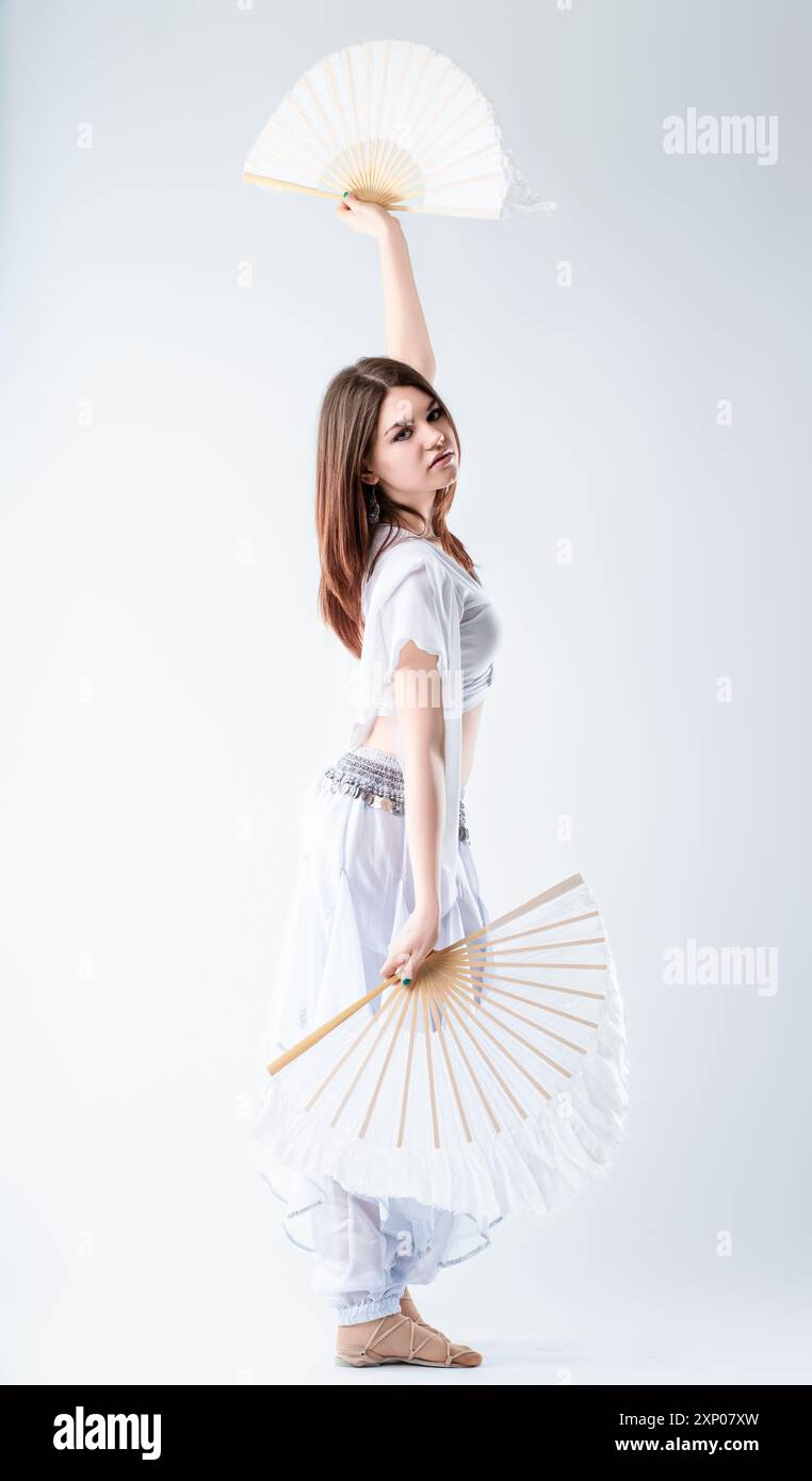 Young woman wearing a white traditional dress is gracefully dancing ...