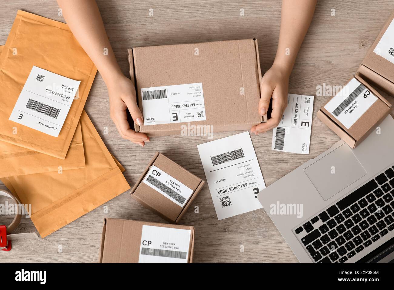 Female postal worker with parcels on table, top view Stock Photo - Alamy