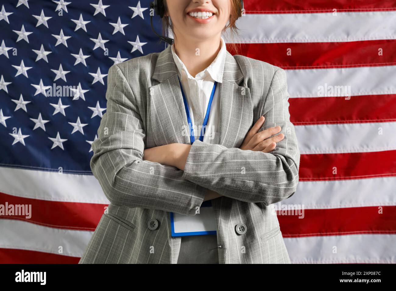 Young female tech support agent standing against USA flag Stock Photo ...