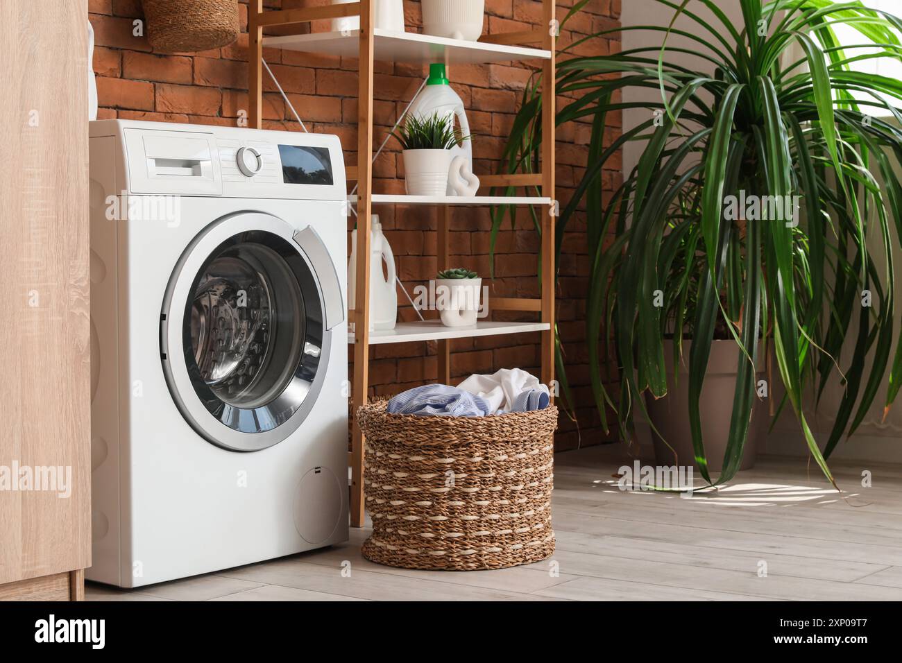 Interior of laundry room with washing machine, basket and shelf unit ...