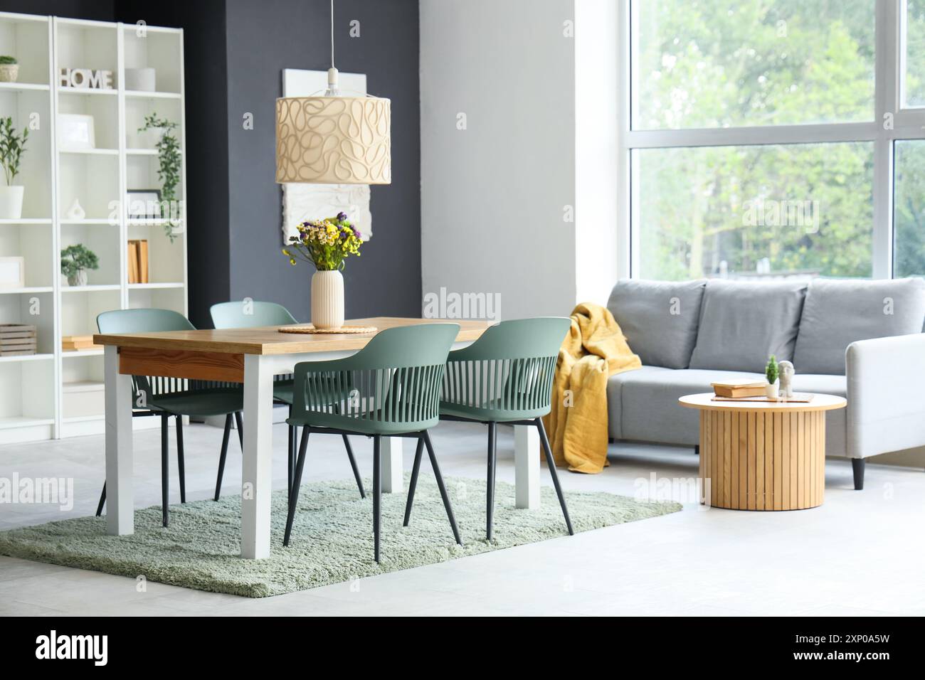Interior of dining room with table, shelf unit and sofa Stock Photo - Alamy