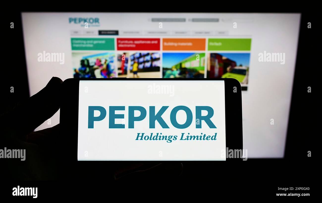 Person holding smartphone with logo of South African company Pepkor ...