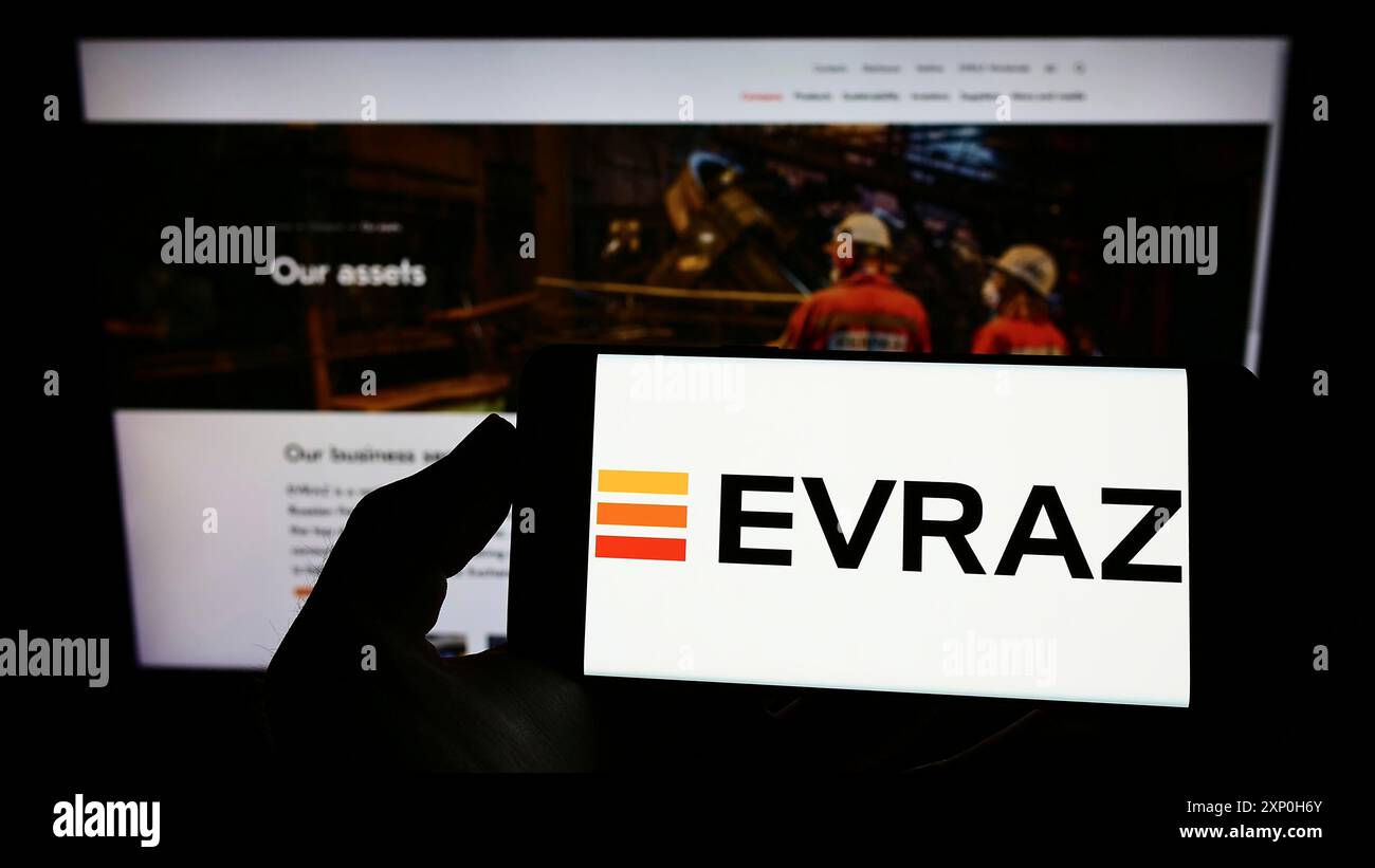 Stuttgart, Germany, 02-20-2022: Person holding mobile phone with logo of British steel and ...