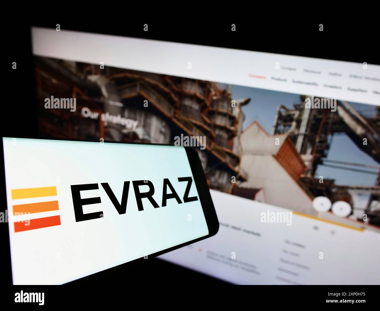 Stuttgart, Germany, 02-20-2022: Mobile phone with logo of British steel and mining company EVRAZ ...