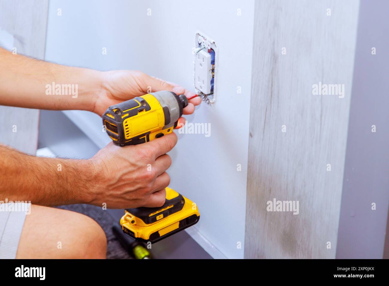 Installing an outlet with screwdriver in house during reconstruction ...