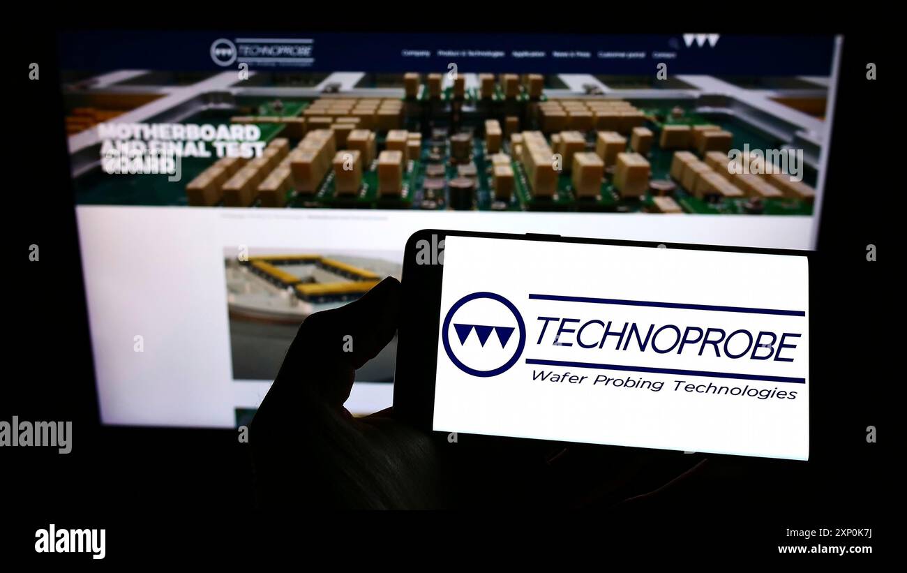 Stuttgart, Germany, 01-23-2022: Person holding smartphone with logo of Italian semiconductor ...