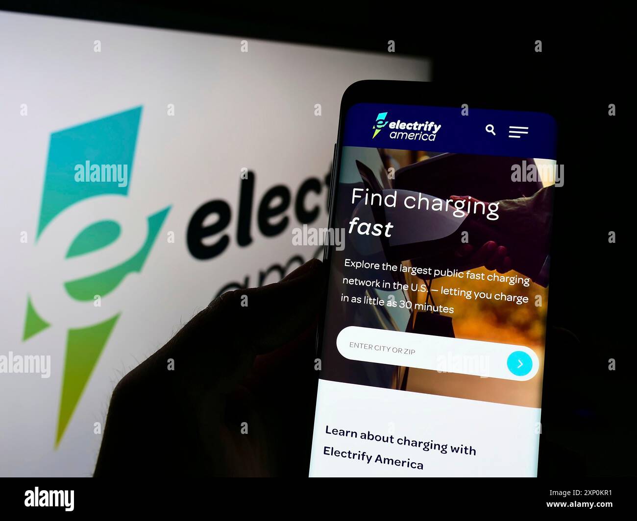 Stuttgart, Germany, 01-09-2022: Person holding cellphone with website of US EV charging company ...