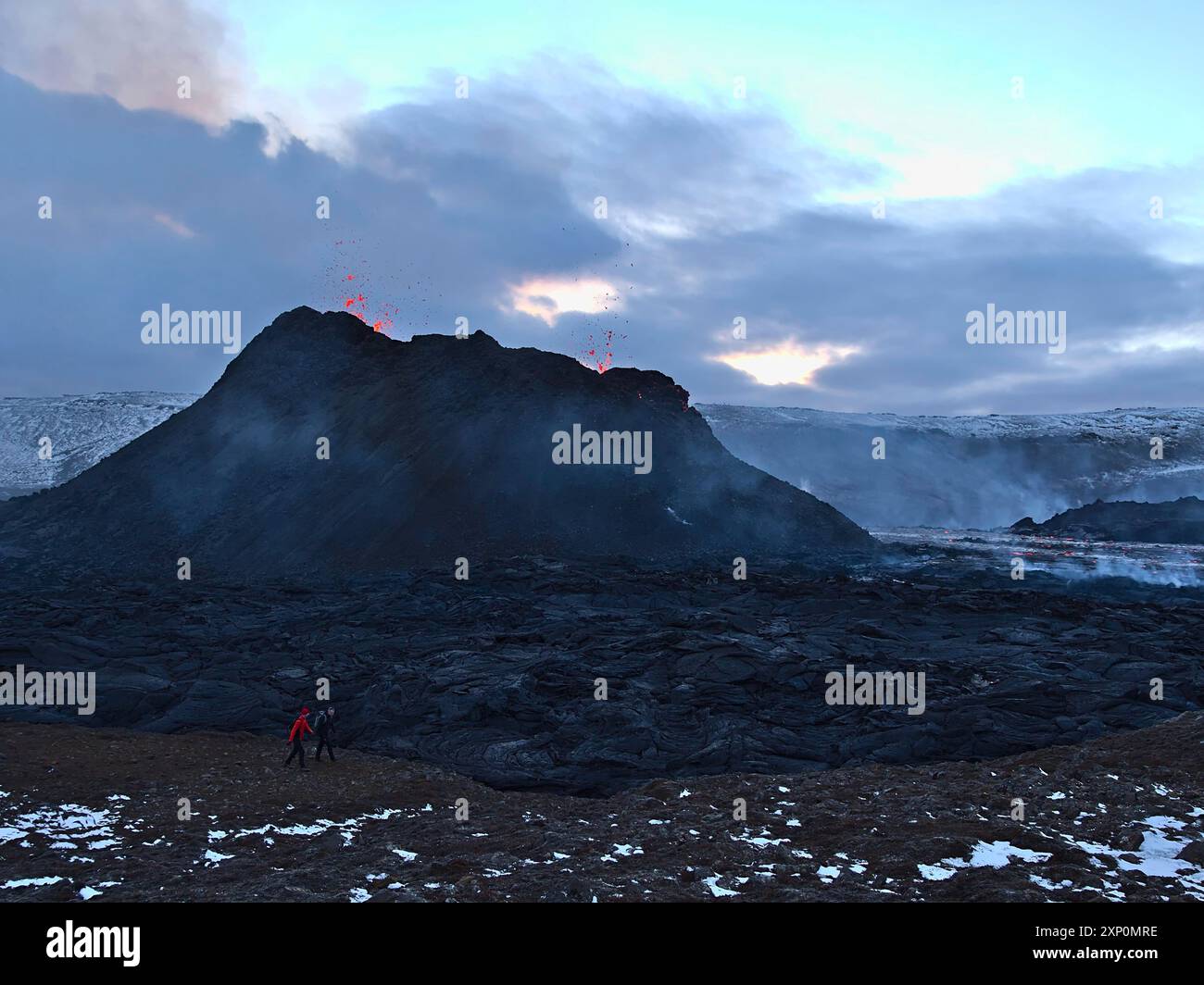 Grindavik, Iceland, 03-29-2021: Two people passing by an erupting ...