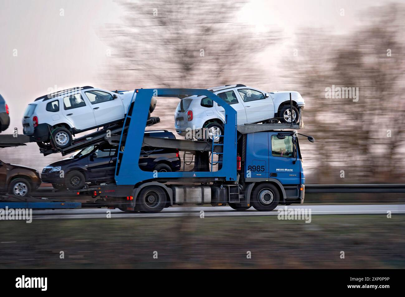 Truck, lorry, articulated lorry with new Dacia cars driving fast on the ...