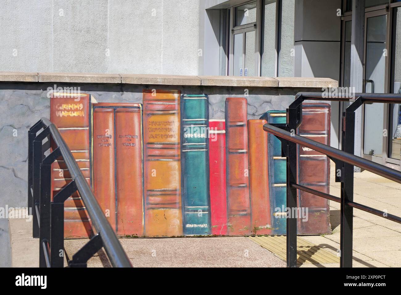 A mural shows colourful books lined up on a wall in the city, Mural ...