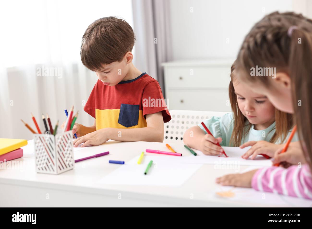 Group of children drawing at table indoors Stock Photo - Alamy