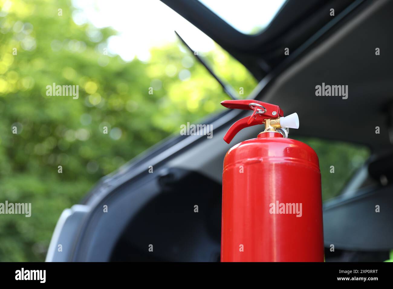 Red fire extinguisher in trunk, closeup. Car safety equipment Stock ...