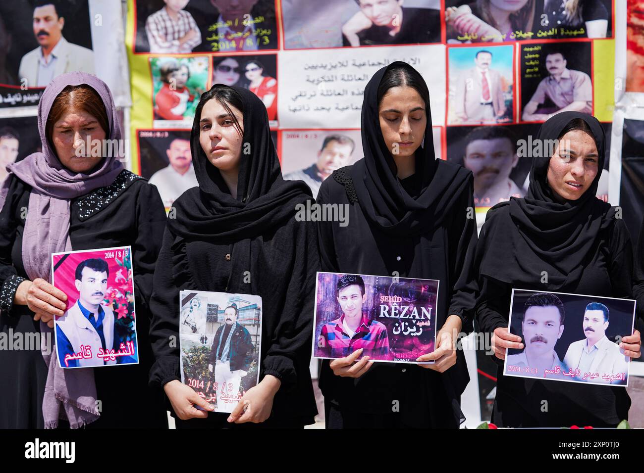 Zakho, Iraq. 01st Aug, 2024. Iraqi Yazidi women hold pictures of their ...