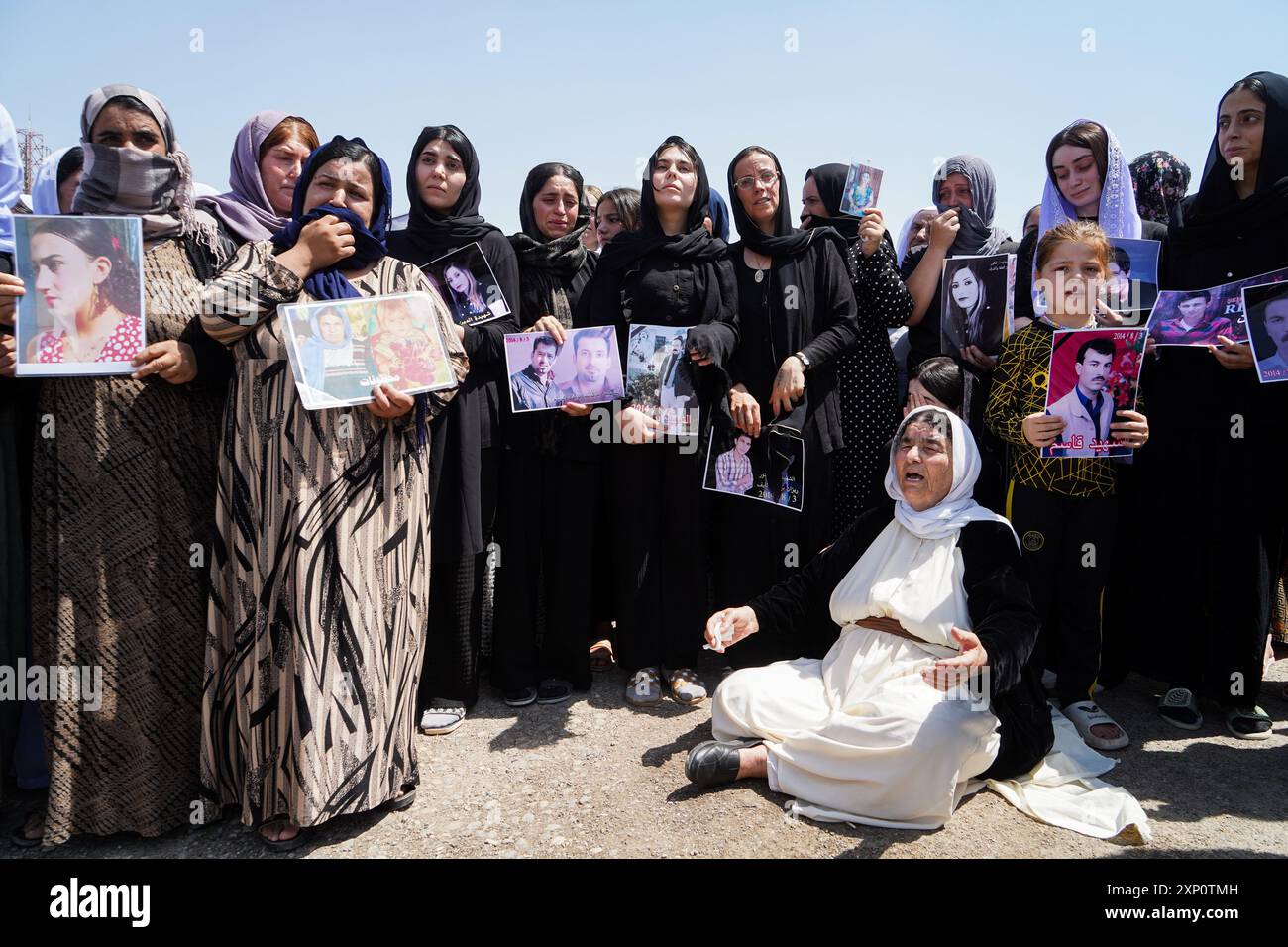 Zakho, Iraq. 01st Aug, 2024. Iraqi Yazidi women hold pictures of their ...