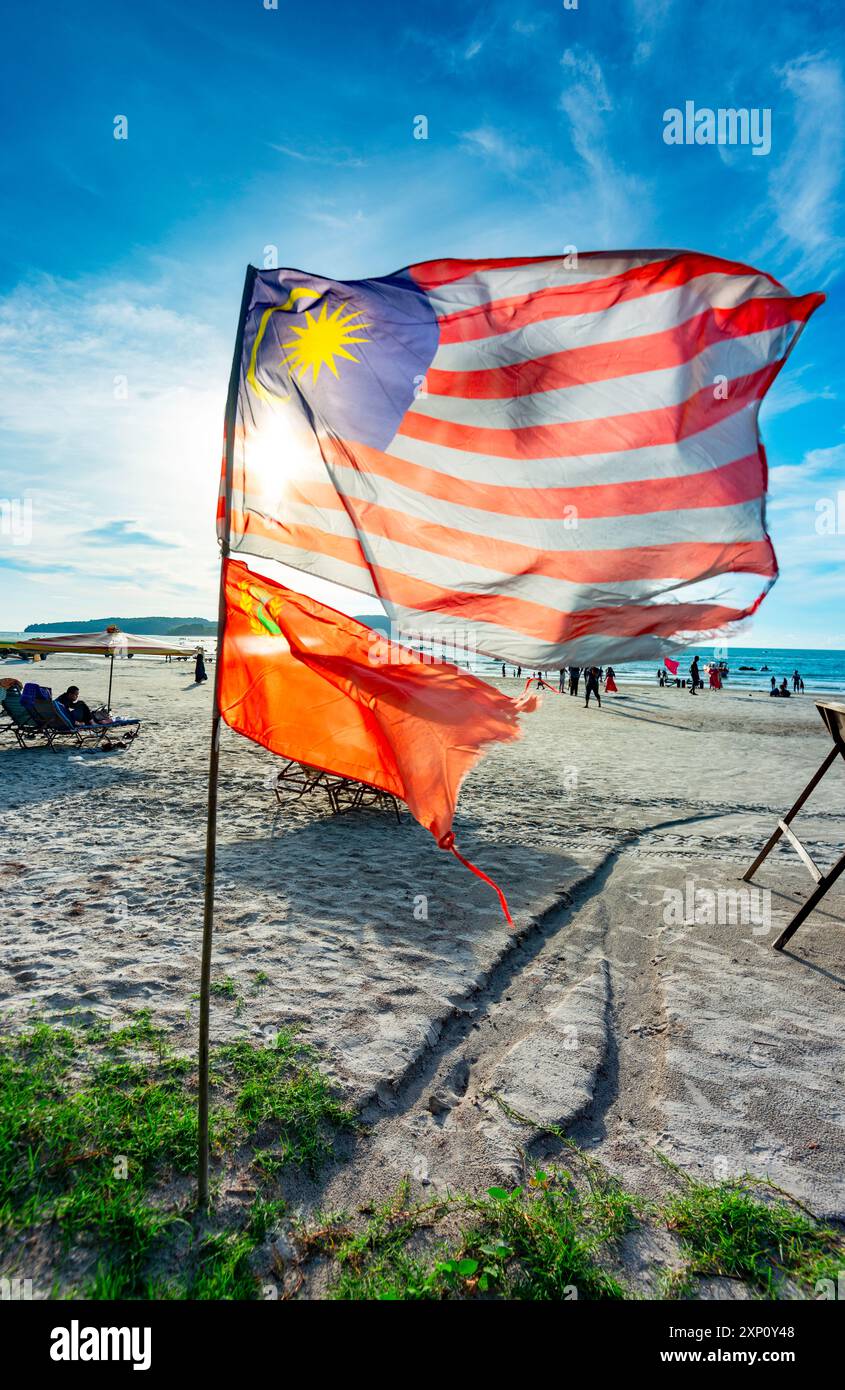 At Cenang beach ,planted into the sand,the Malaysian flag flaps in the ...