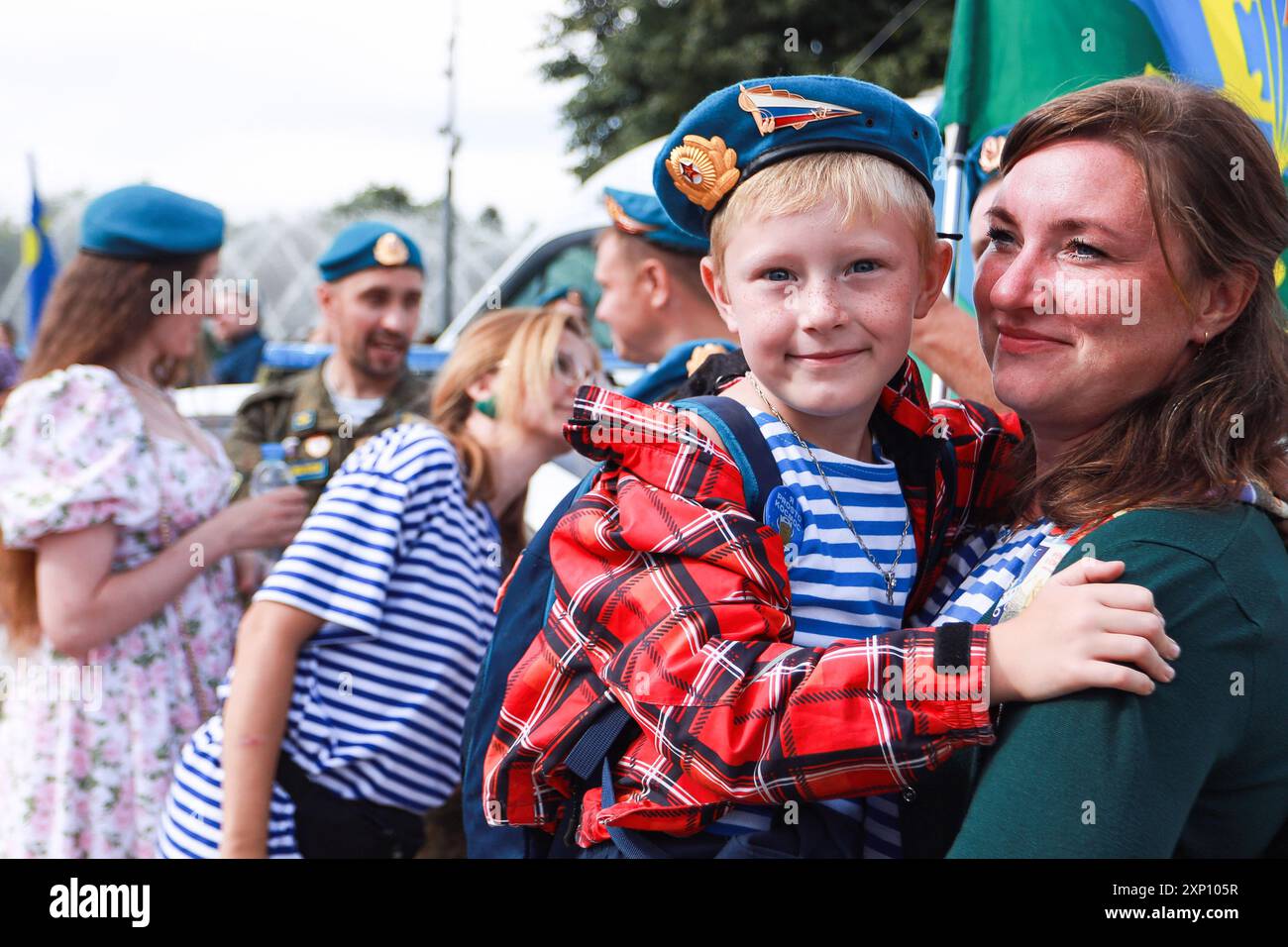 A woman carries a boy in an Airborne Forces cap during the celebration ...