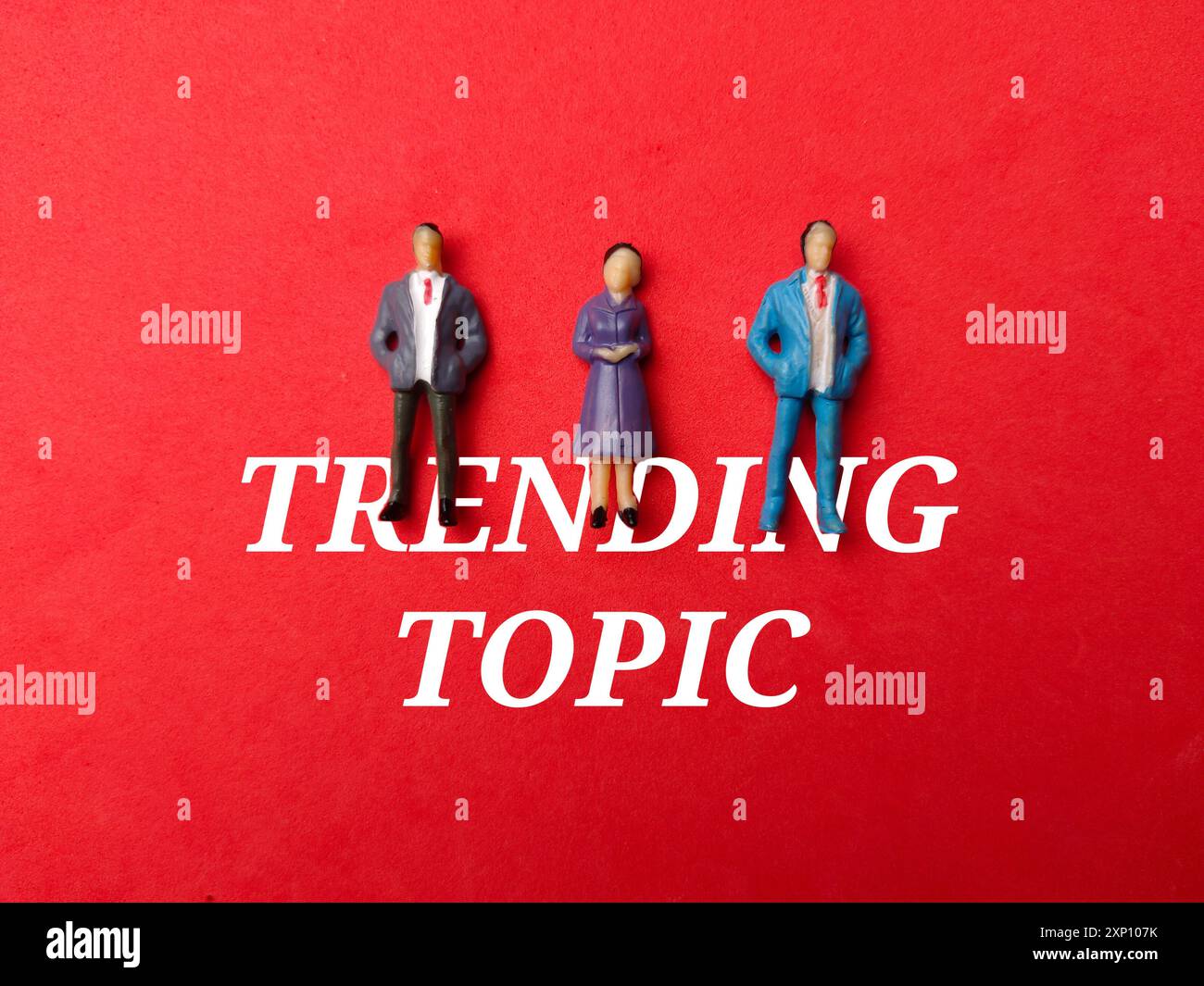 Miniature people with text TRENDING TOPIC on a red background Stock ...