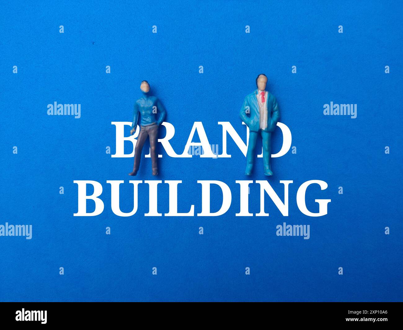 Miniature people with text BRAND BUILDING on a blue background Stock ...
