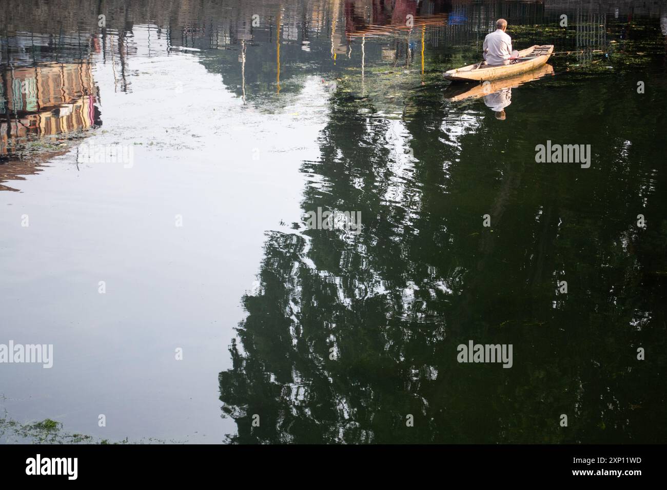 Shikara floats on the reflective surface of Dal Lake Stock Photo - Alamy