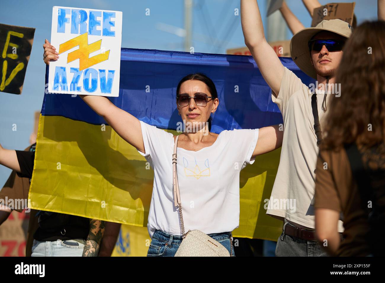 Ukrainian patriot posing with a national flag and banner Free Azov ...