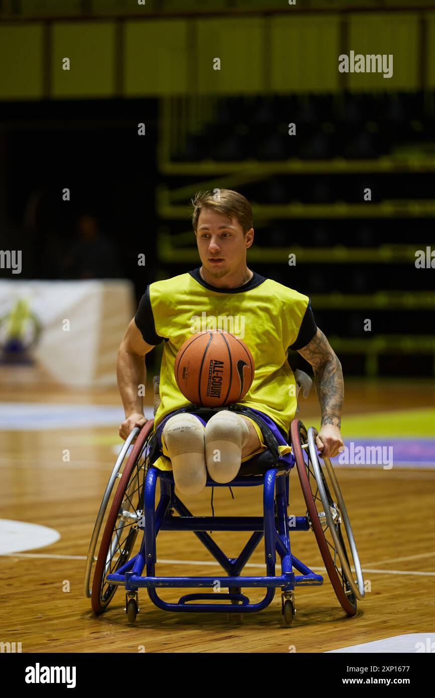 Wounded veteran playing adaptive basketball on court. Young athlete ...