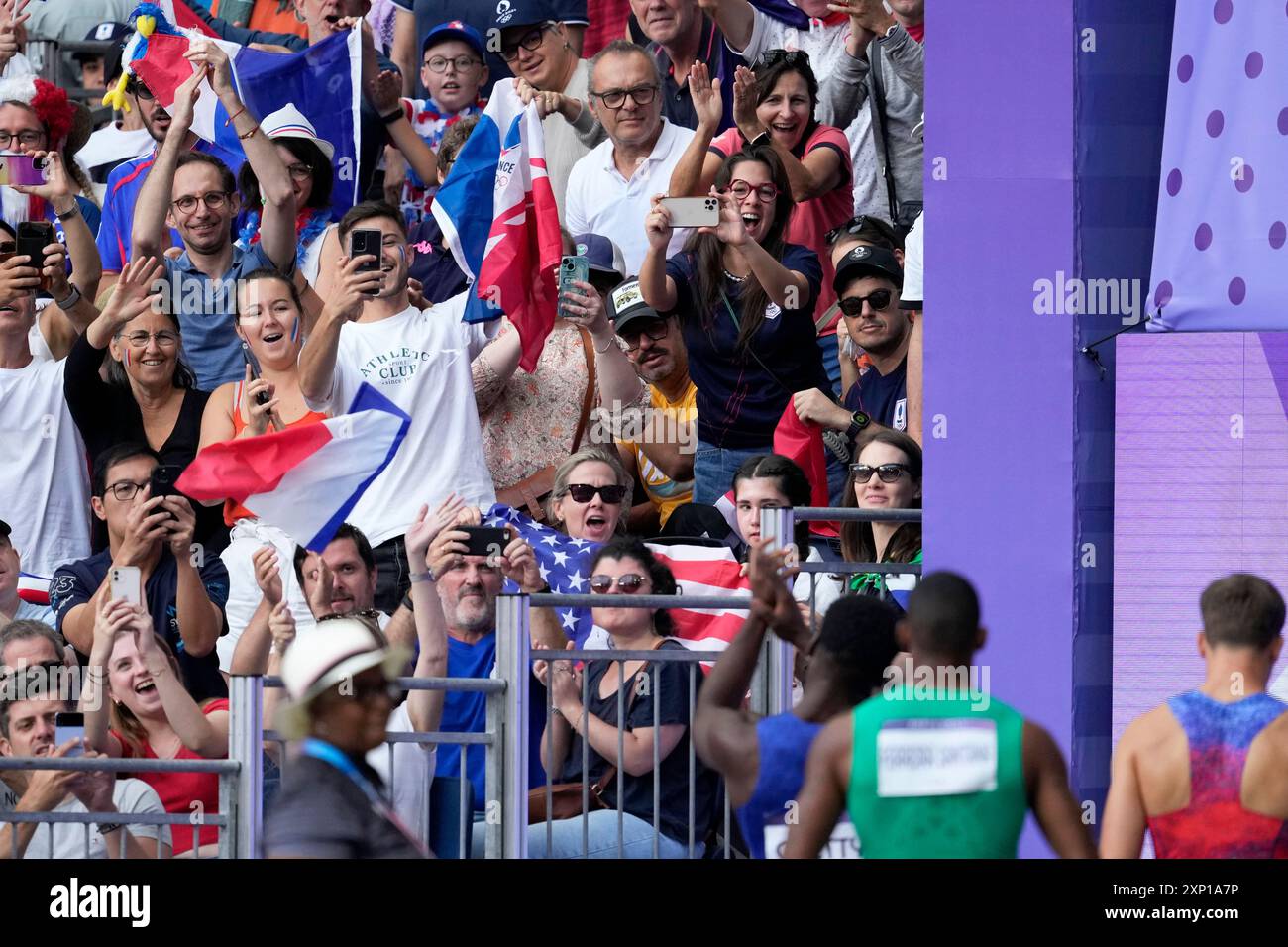 Fans cheer on the athletes as they leave the track after the decathlon ...