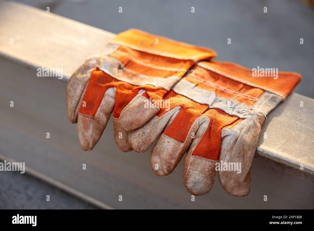 Yellow dirty work gloves on a metal bar stained with grease and oil ...