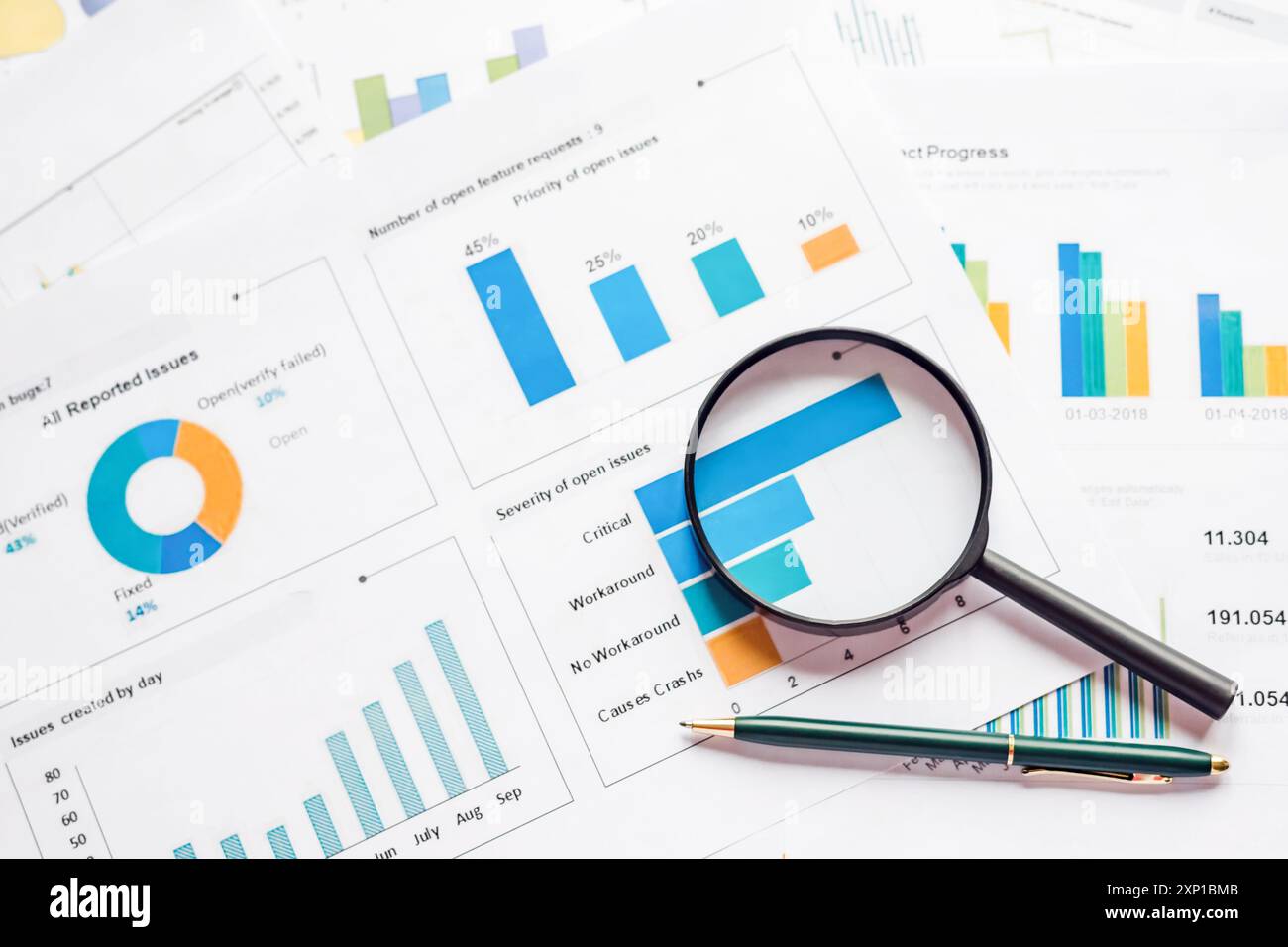 Above view of white office desk with pen, magnifier and business ...