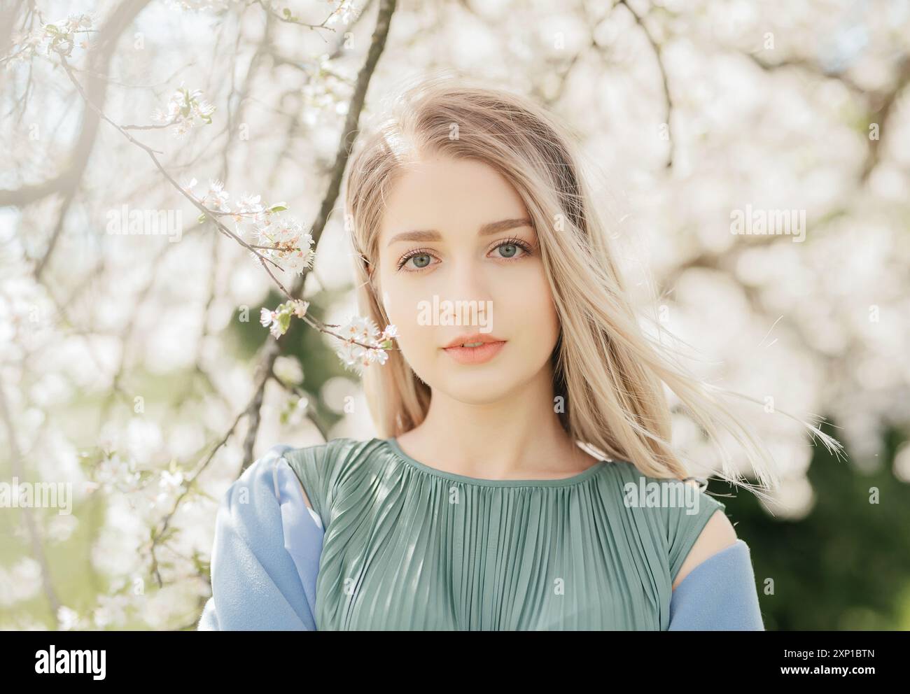 Portrait of young woman in the flowered garden in the spring time. Girl ...