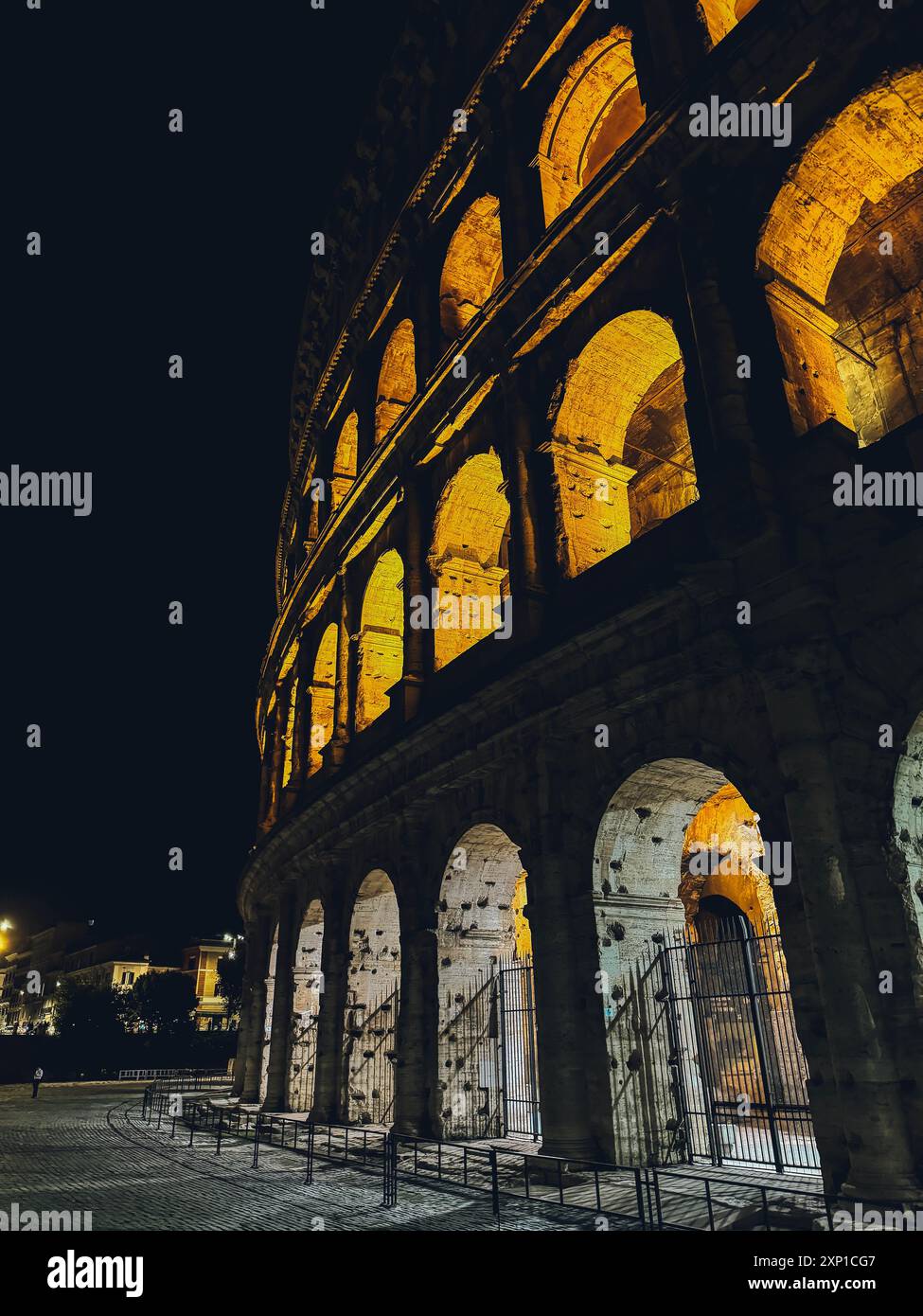 The building is lit up in yellow and orange, giving it a warm and ...