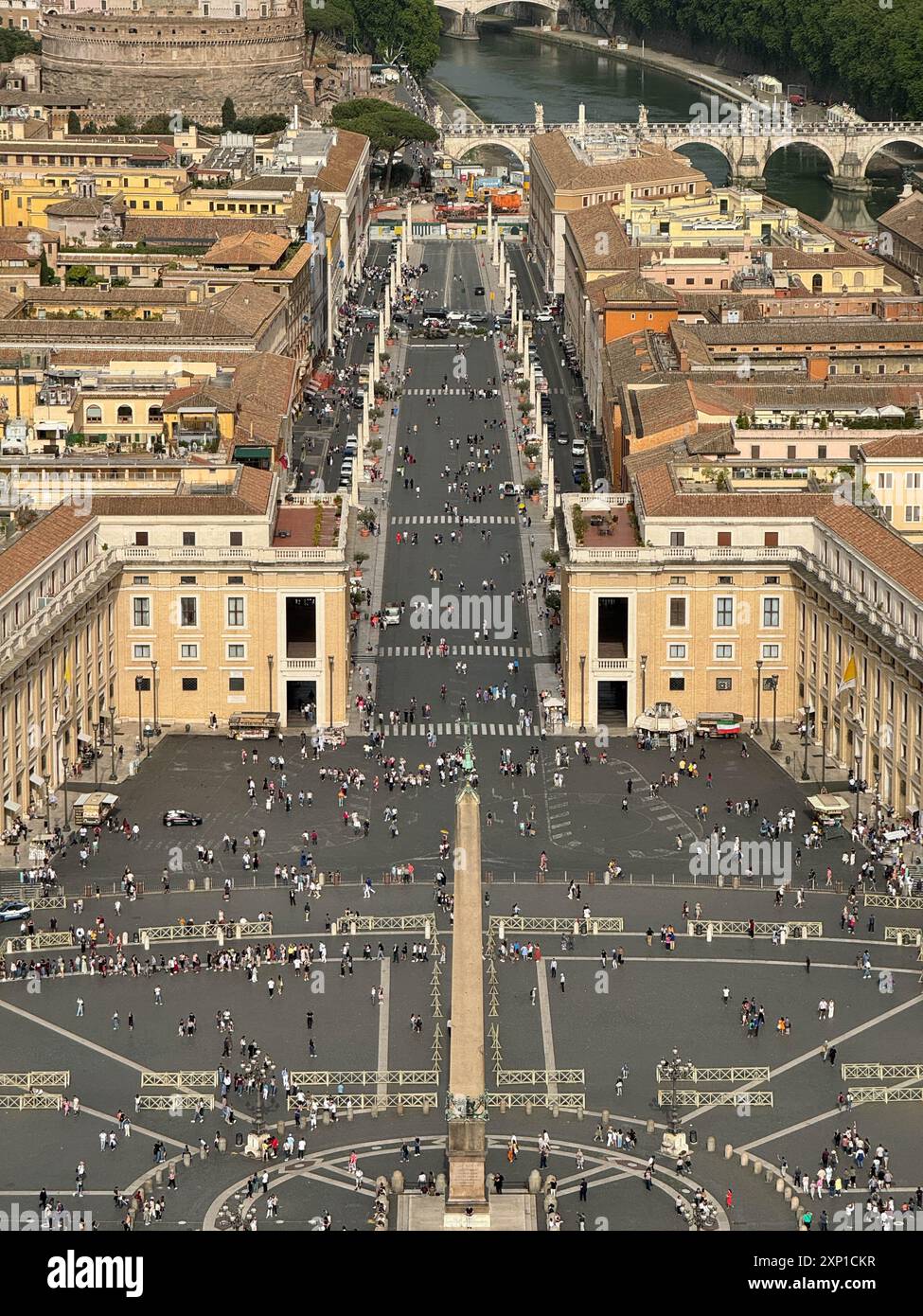 A large city street with a large crowd of people walking down it. The ...