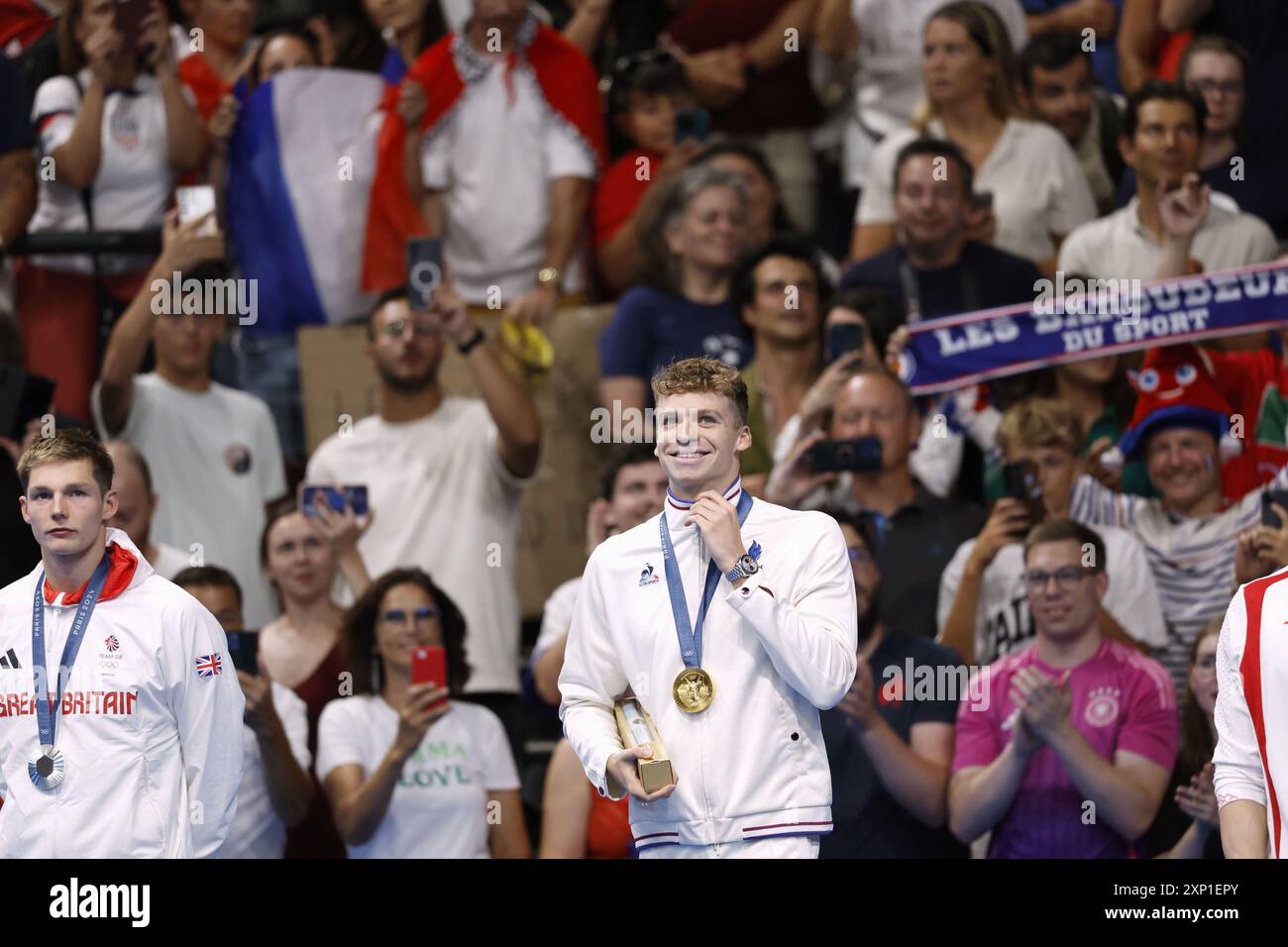 Leon Marchand of France (C) poses with his gold medal for the men's 200 ...