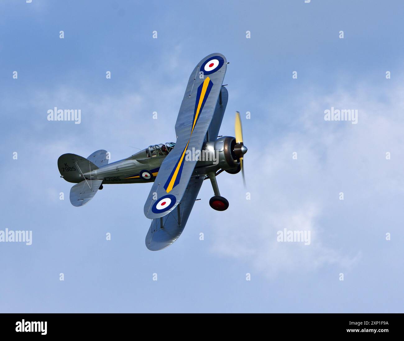 Vintage Gloster Gladiator aircraft in flight with cloud and blue sky ...