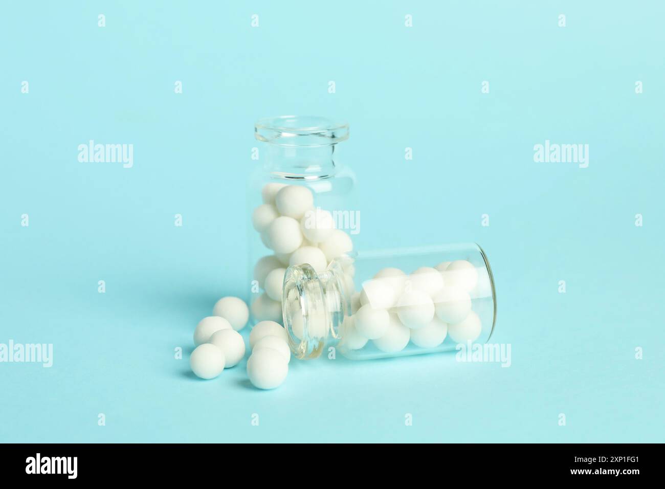 Homeopathy. Glass bottles with pills on light blue background Stock ...