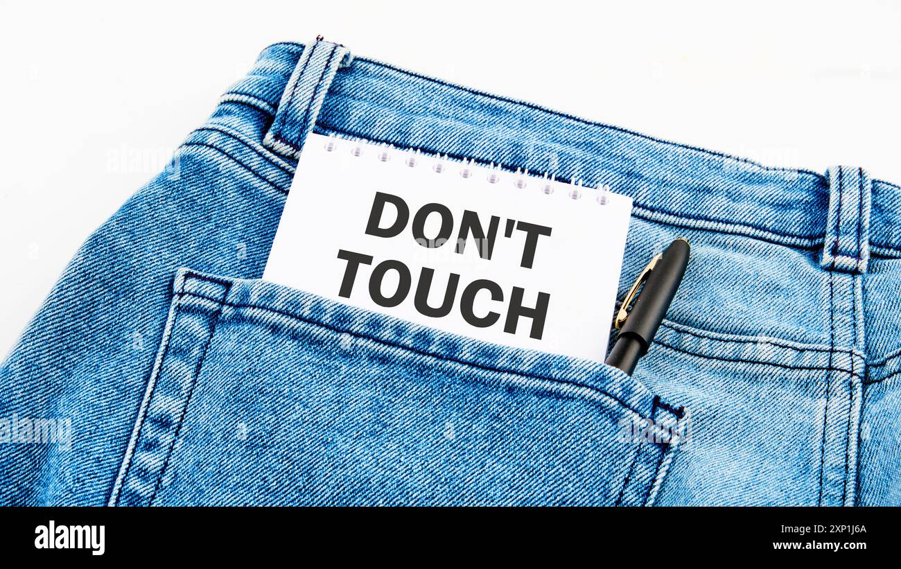 Do not Touch ME text written on a notebook on jeans on a white ...