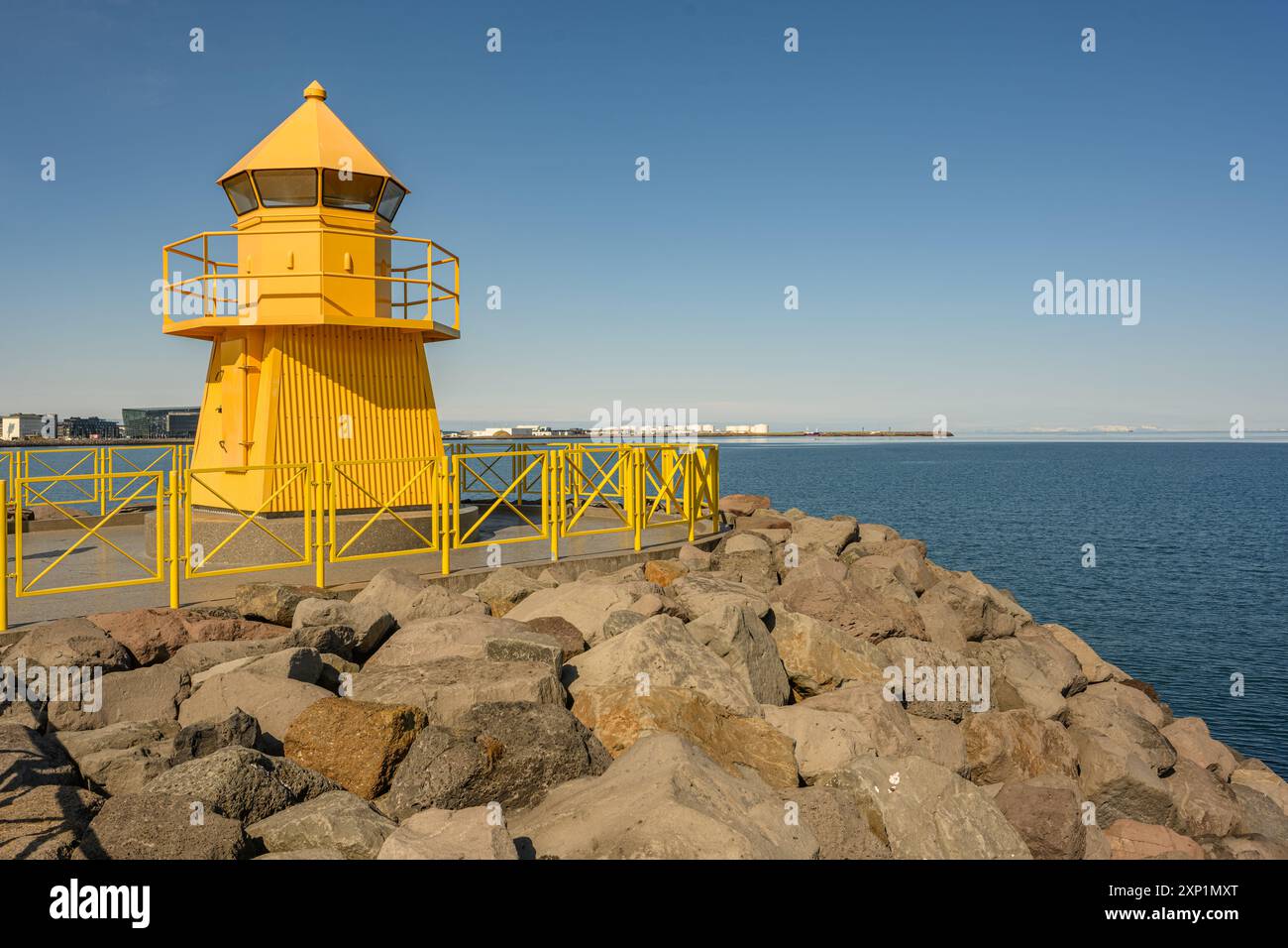 The historic yellow Hofoi lighthouse on the rocky shore of Reykjavik ...