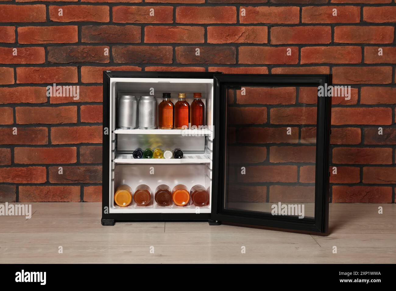 Mini refrigerator with drinks near brick wall Stock Photo - Alamy